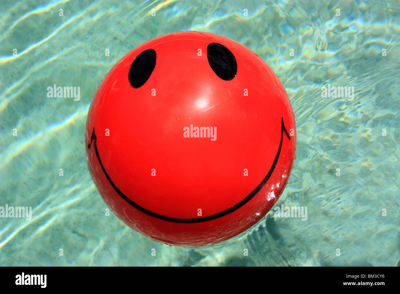 RED BALL WITH BLACK SMILEY FACE DESIGN FLOATING IN SWIMMING POOL BDA ...