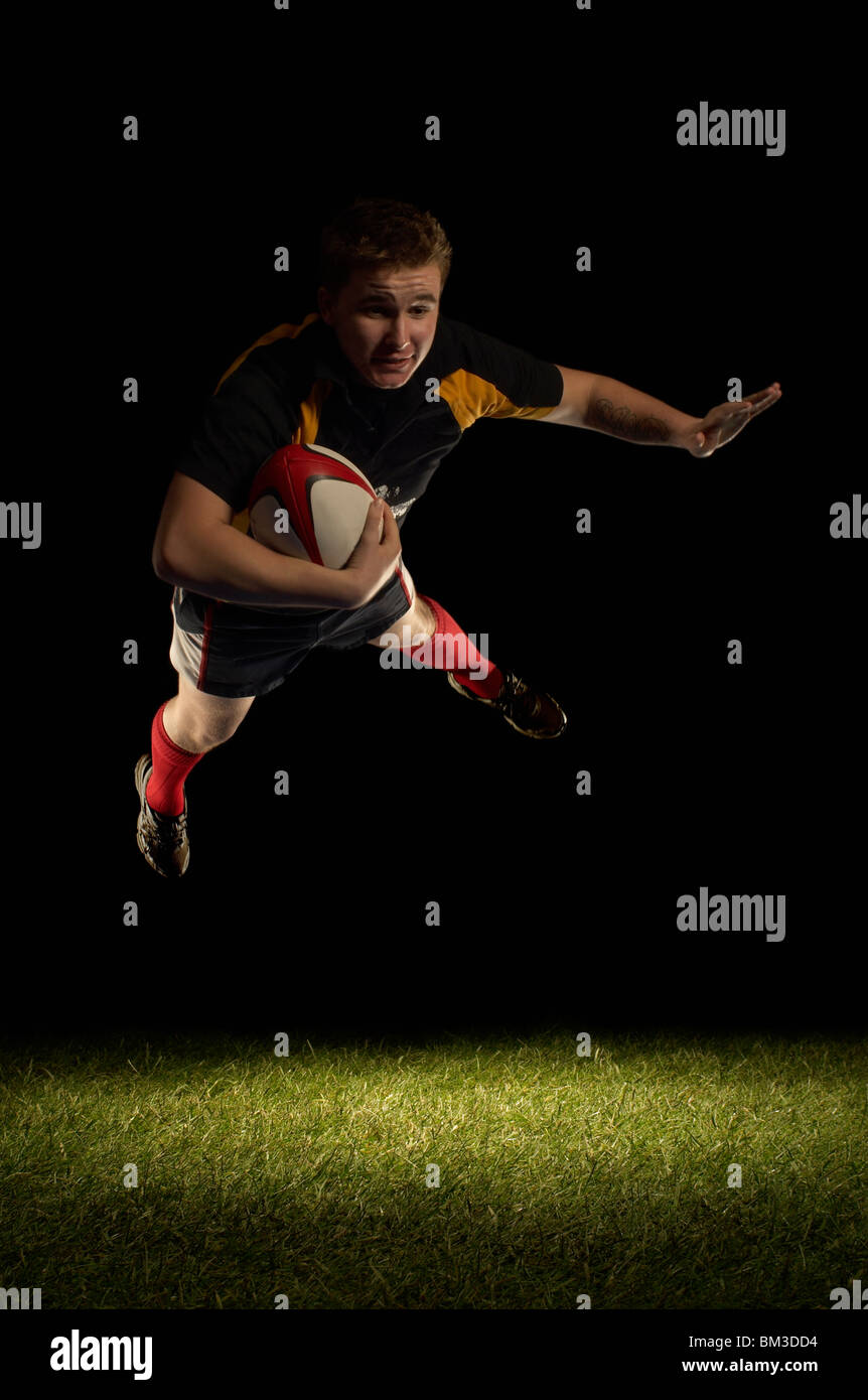 Rugby player mid air with ball Stock Photo - Alamy