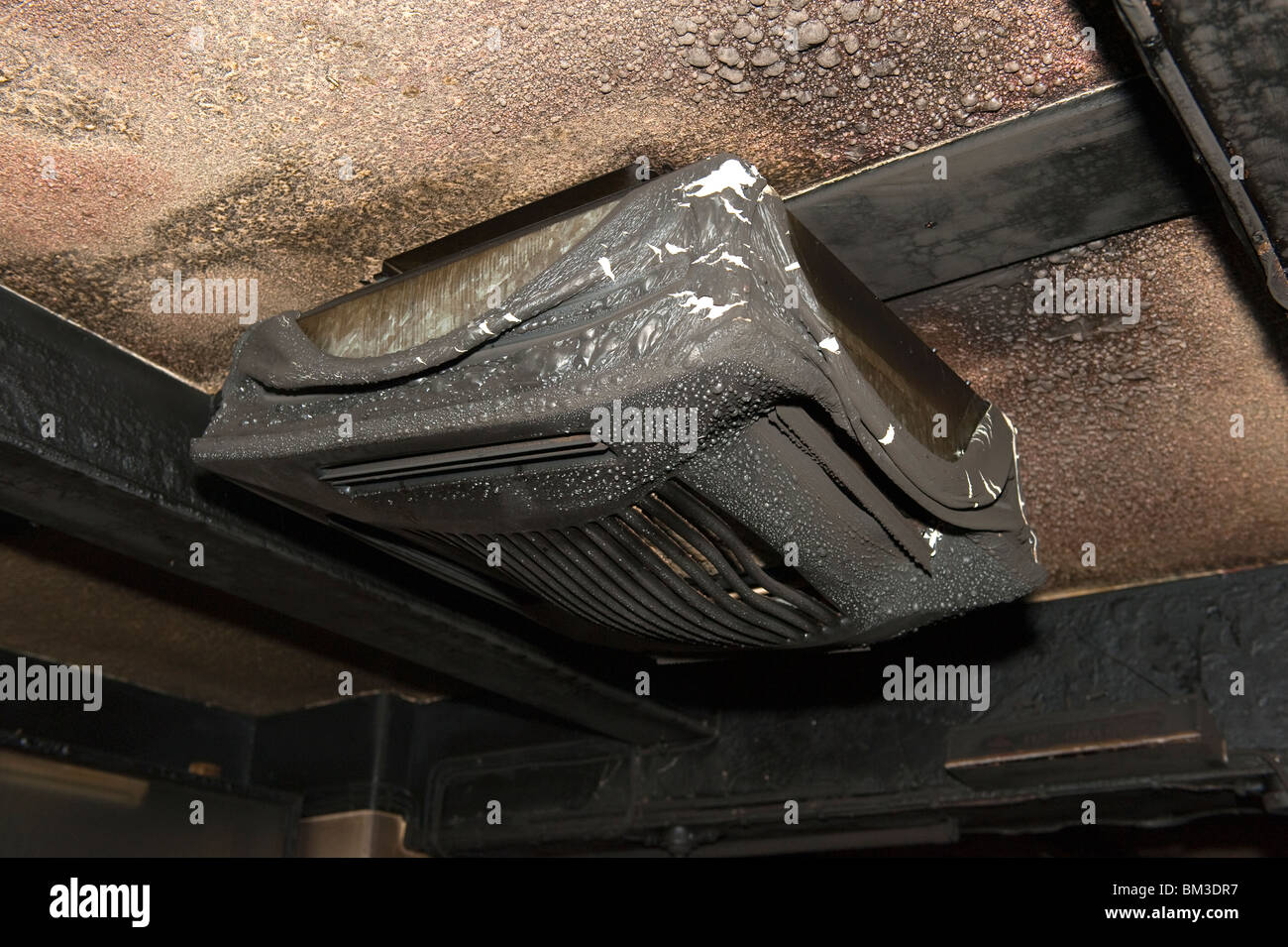 Melted burnt air conditioning unit in ceiling Stock Photo - Alamy