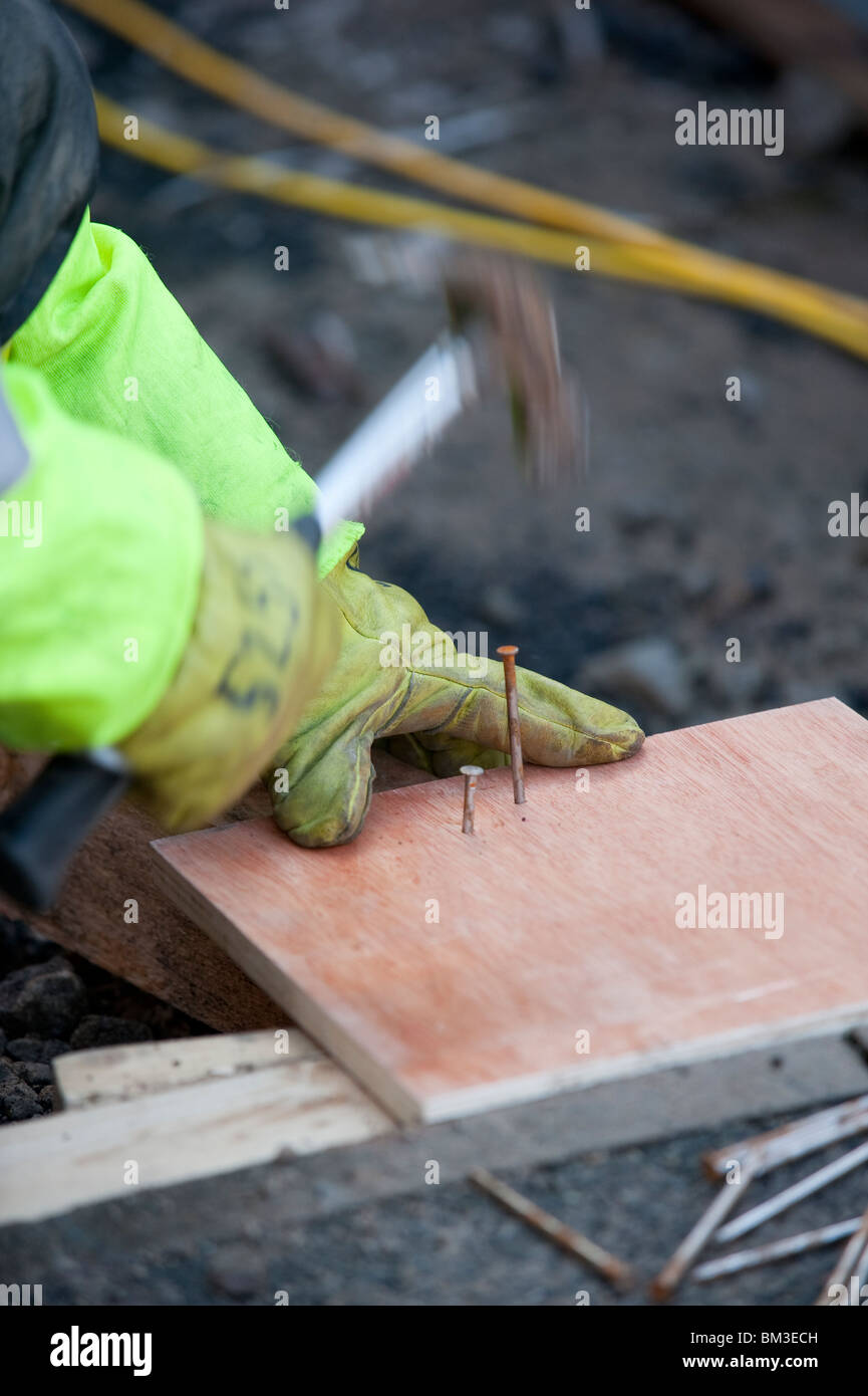 Hammer nailing nail into block of wood FULLY MODEL RELEASED Stock Photo ...
