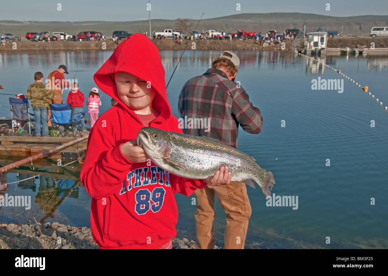 This little Caucasian boy is proudly holding his prize trout fish he ...
