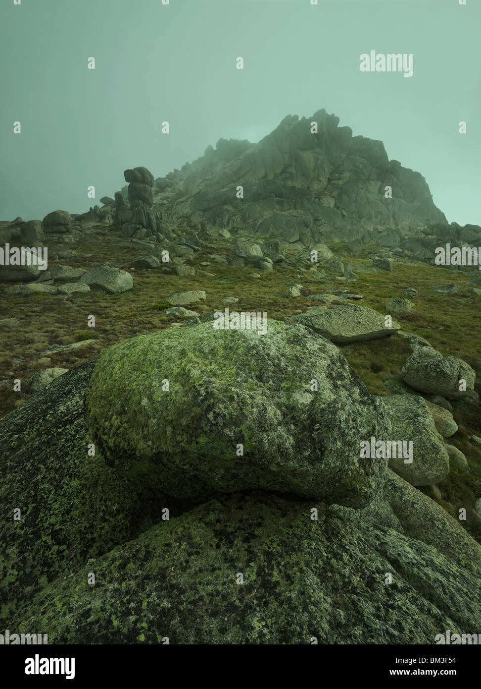 A wedged boulder with a view to a mist veiled North Rams Head ...