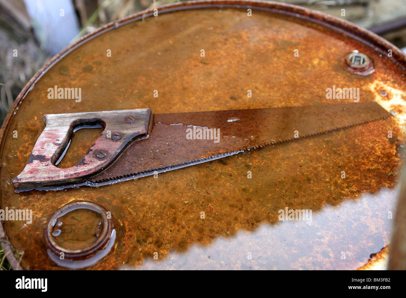 Rusted old saw tool over rusty orange background Stock Photo - Alamy
