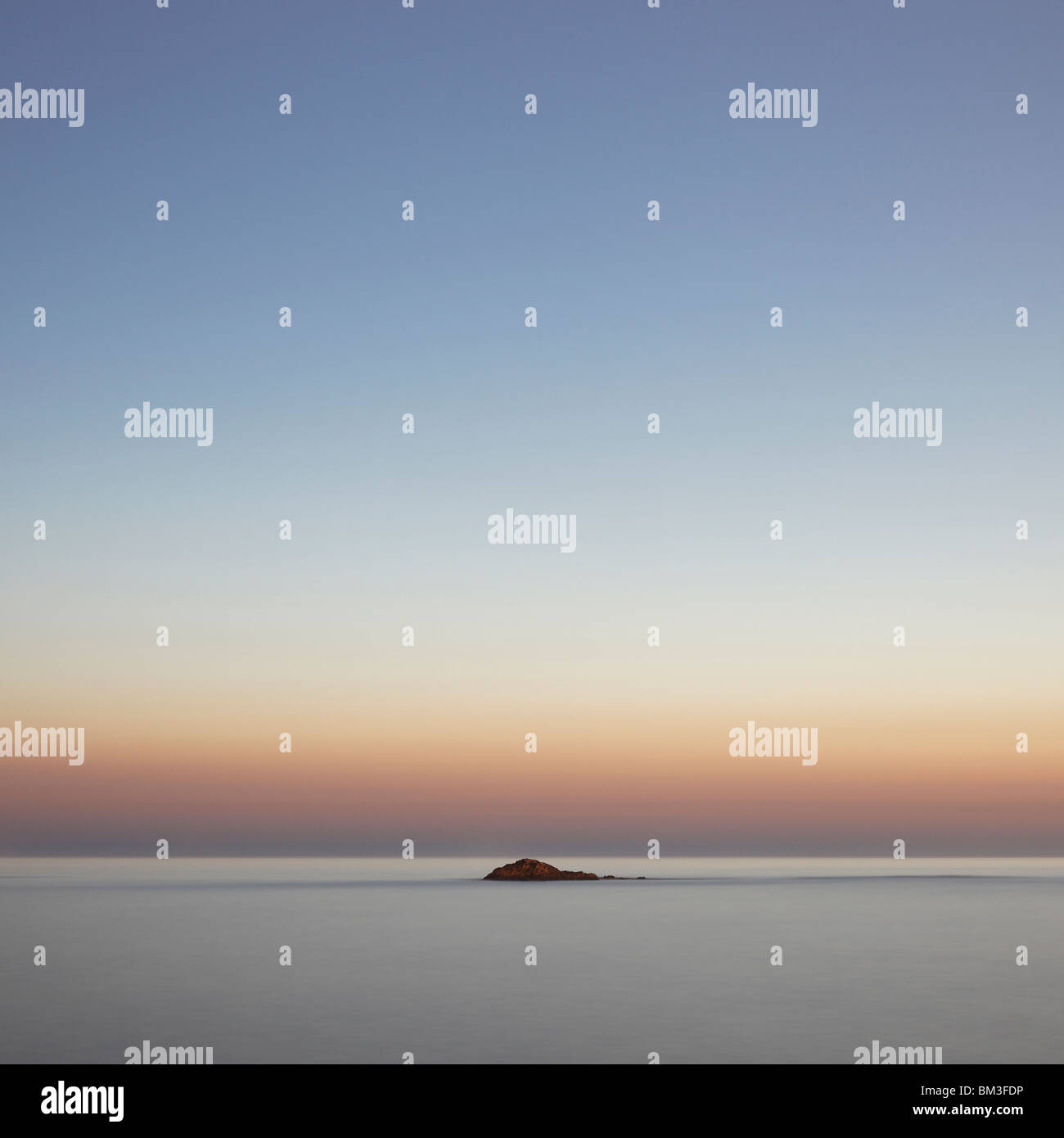 Rock in sea at sunset Stock Photo - Alamy