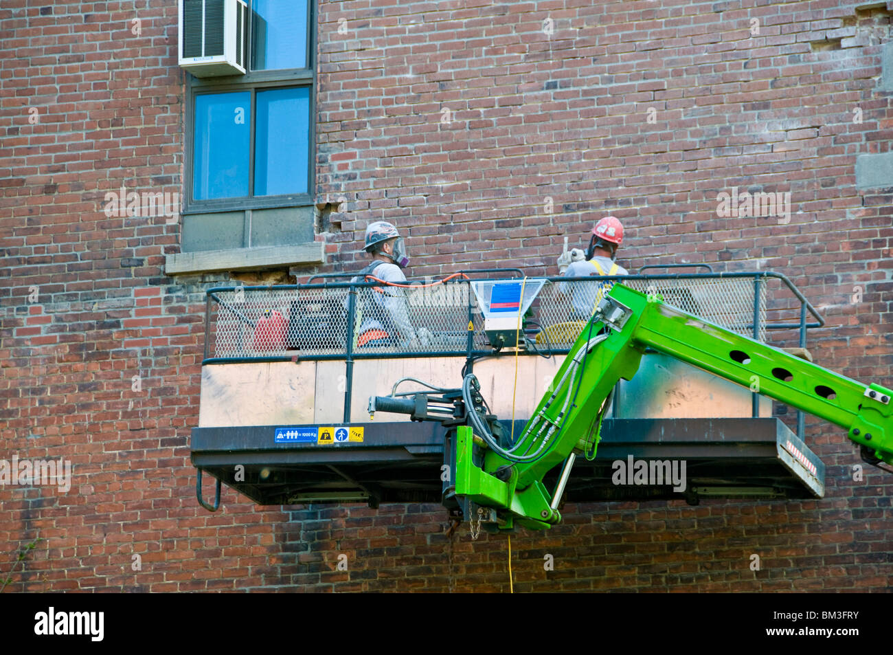 Workers restoring wall of a brick building Stock Photo - Alamy