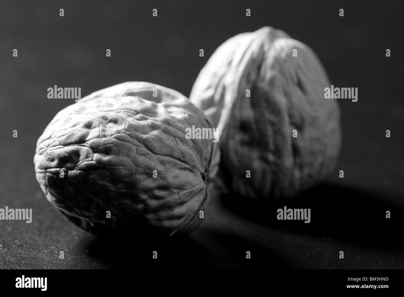 Two walnuts with shells over black background Stock Photo - Alamy