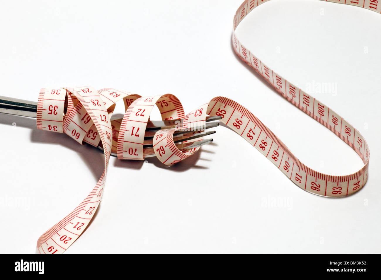 An image of a flexible measurement tape wrapped around a silver fork ...