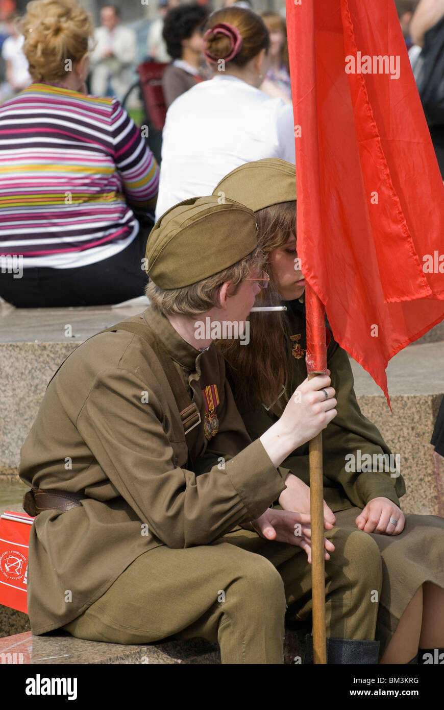 Two Russian young people in Soviet military uniform sitting on parapet ...