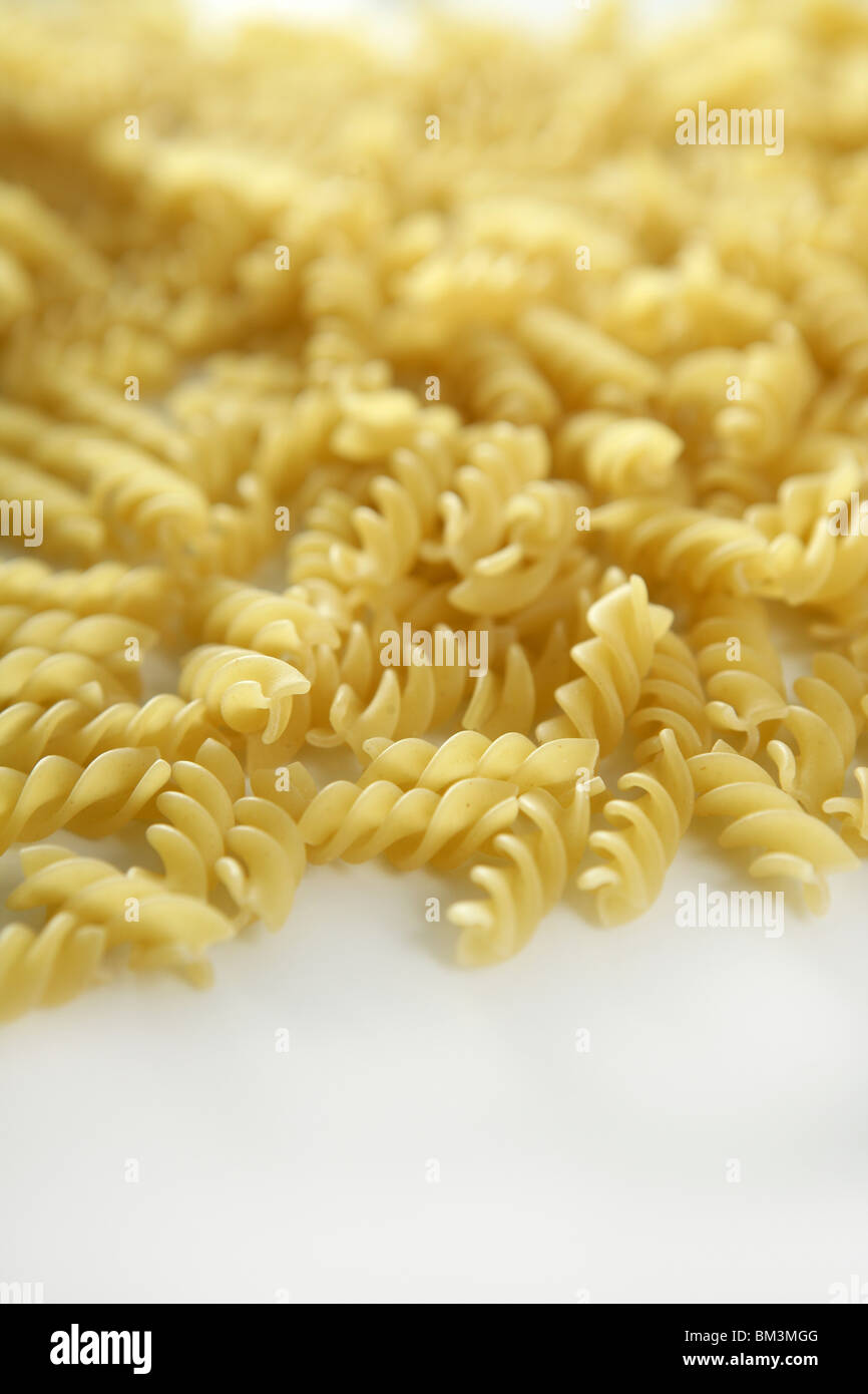 Italian spiral pasta texture with selective focus, white studio ...