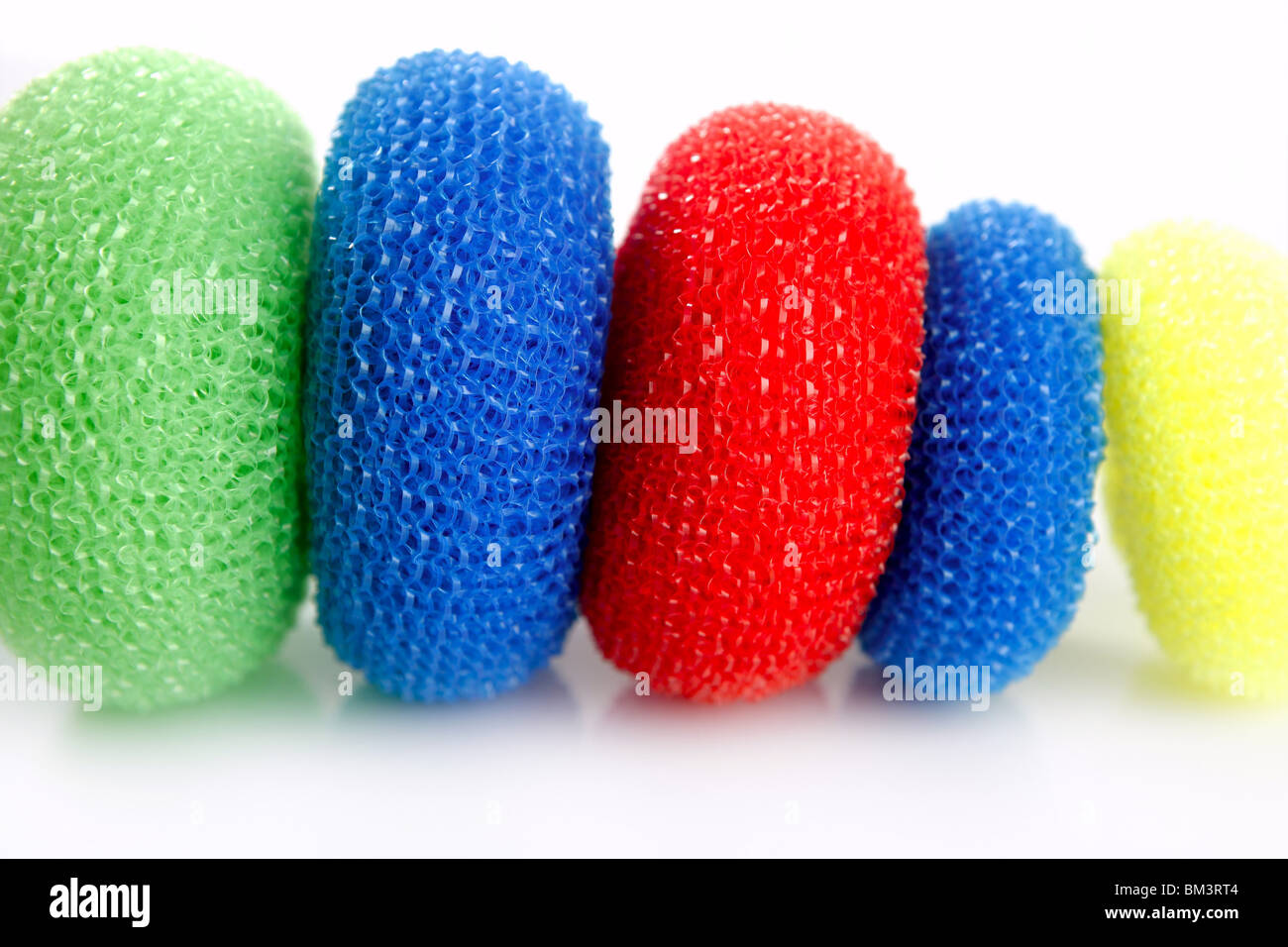 Domestic colorful sponge washer for dishes in a row isolated over white ...