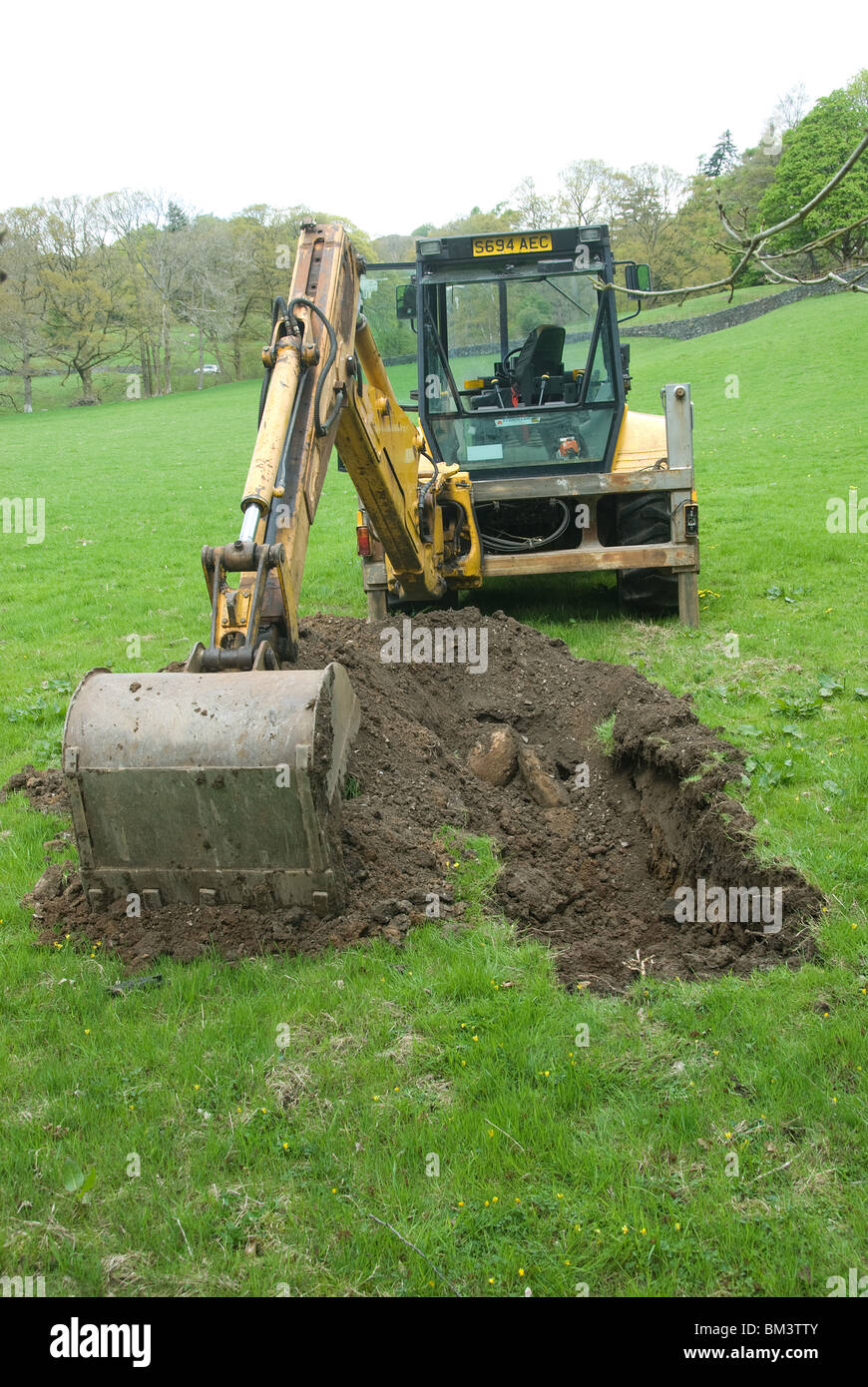 Mechanical digger in Cumbrian field Stock Photo - Alamy