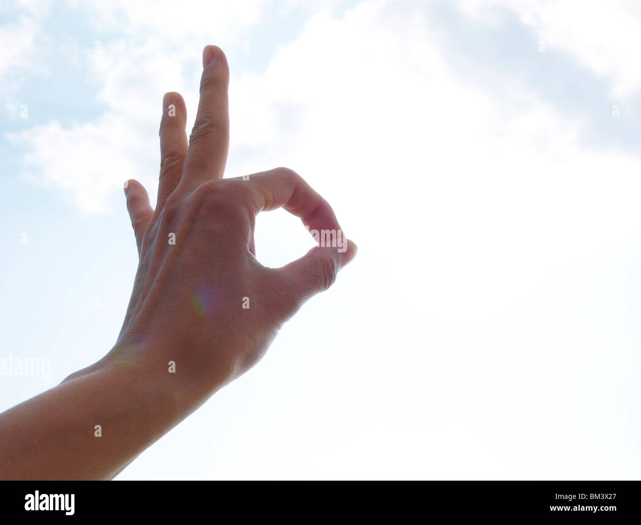 Woman's hand making OK sign against sky Stock Photo - Alamy