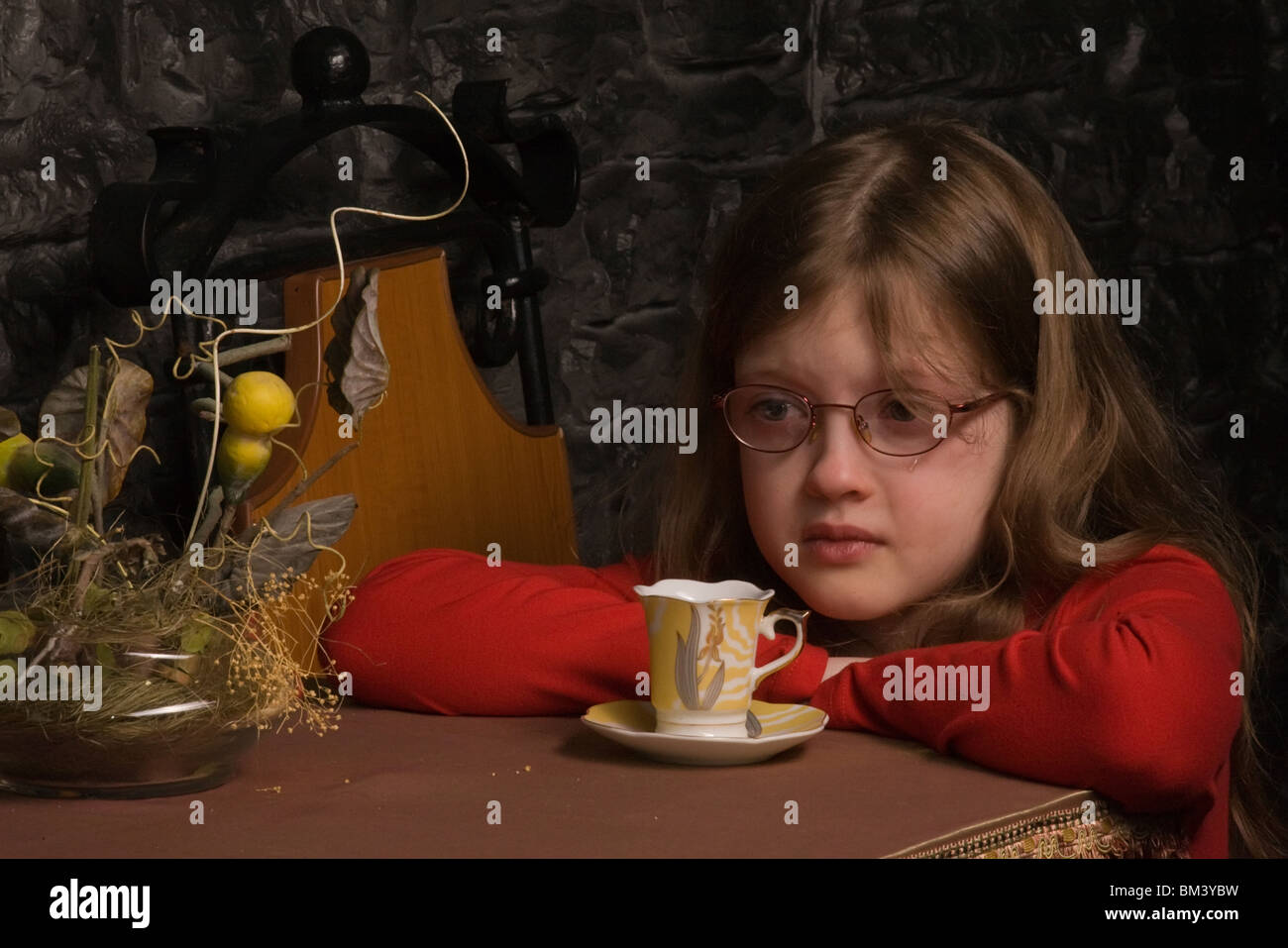 A little whining girl lonely sit at the table in a restaurant Stock ...