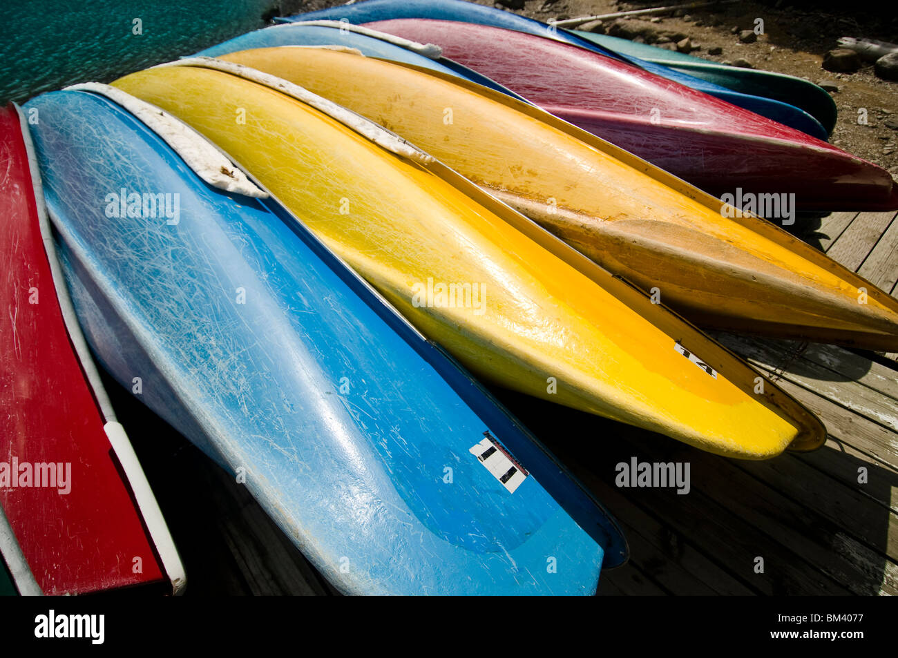 Colourful canoes on the shore await eager paddlers Stock Photo - Alamy