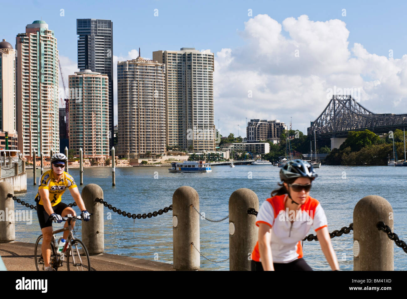 Cyclists on the riverside with Story Bridge in the background. Brisbane ...