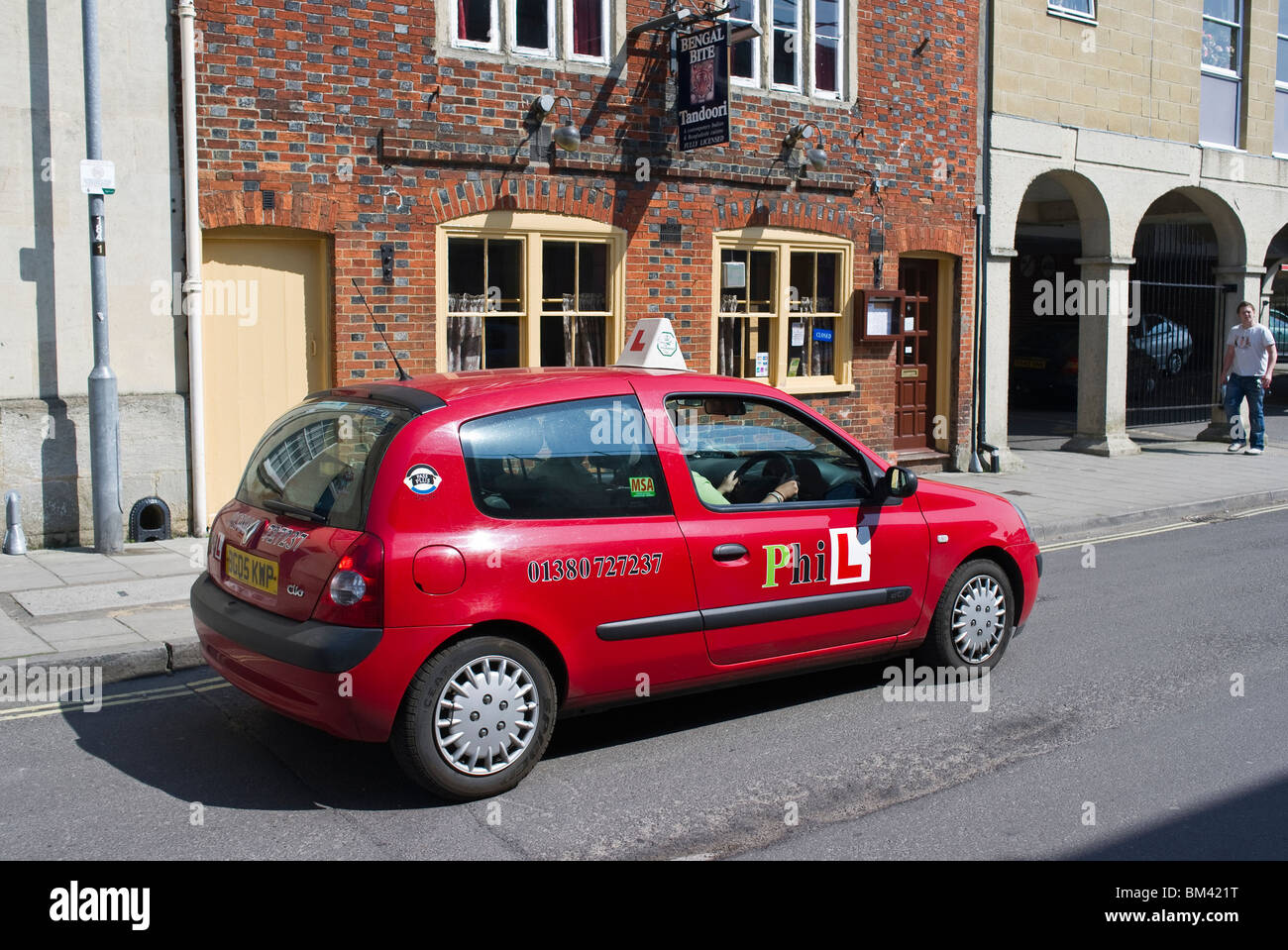 Red Renault Clio saloon car being used for driving instruction Stock ...