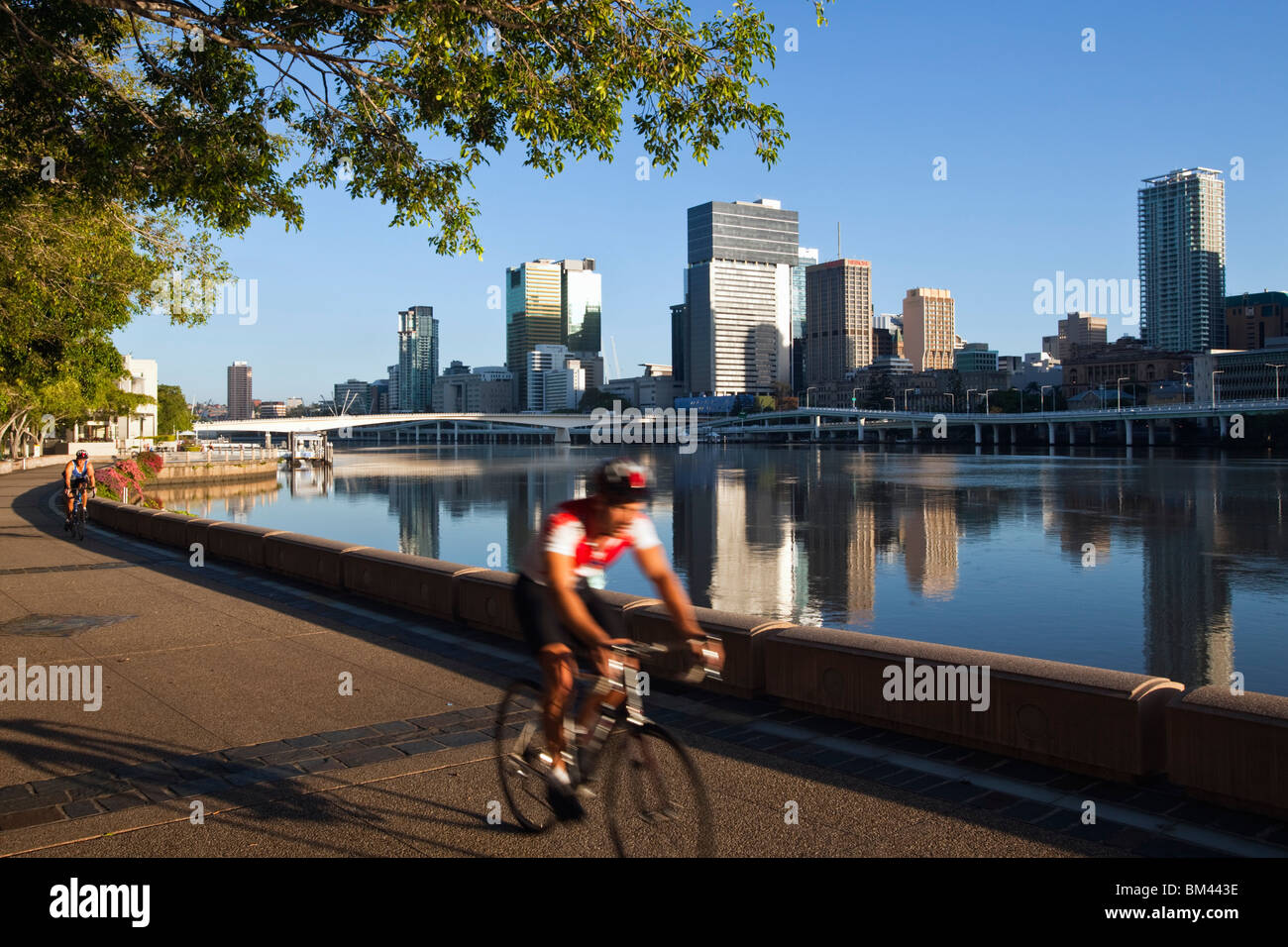 Cyclist on the riverside at South Bank with city skyline in the ...