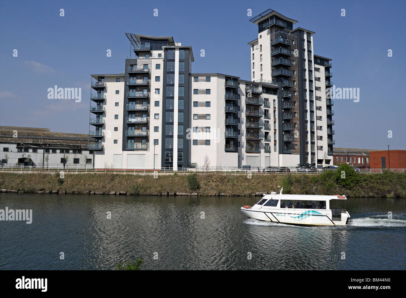 Cardiff Bay Aquabus passing a modern riverside residential block, river ...