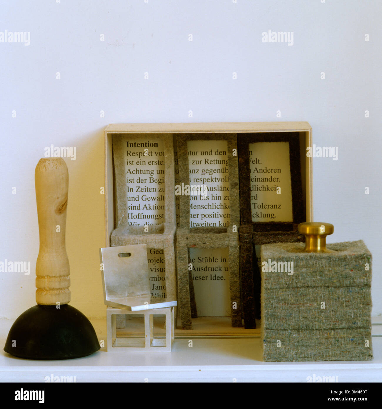 Model chairs collection displayed with a kitchen plunger on a shelf in ...