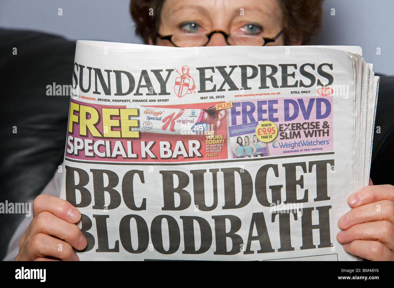 Woman reading a copy of the Sunday Express newspaper Stock Photo - Alamy