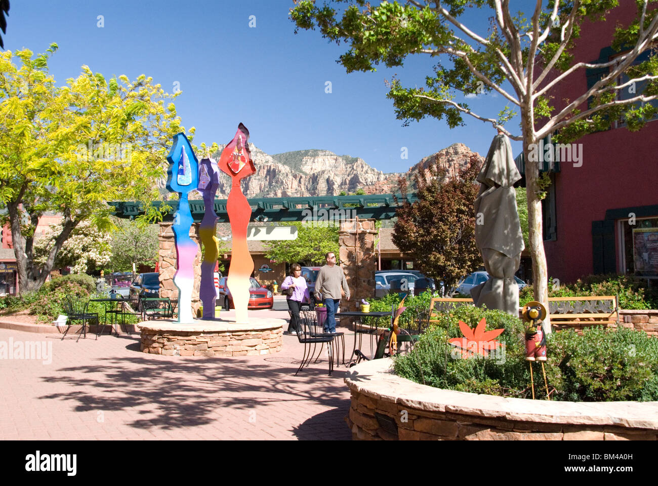 Small shopping mall with outdoor sculpture and café seating main street ...