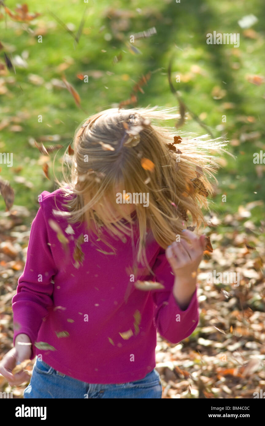 Girl playing in falling Autumn leaves Stock Photo - Alamy