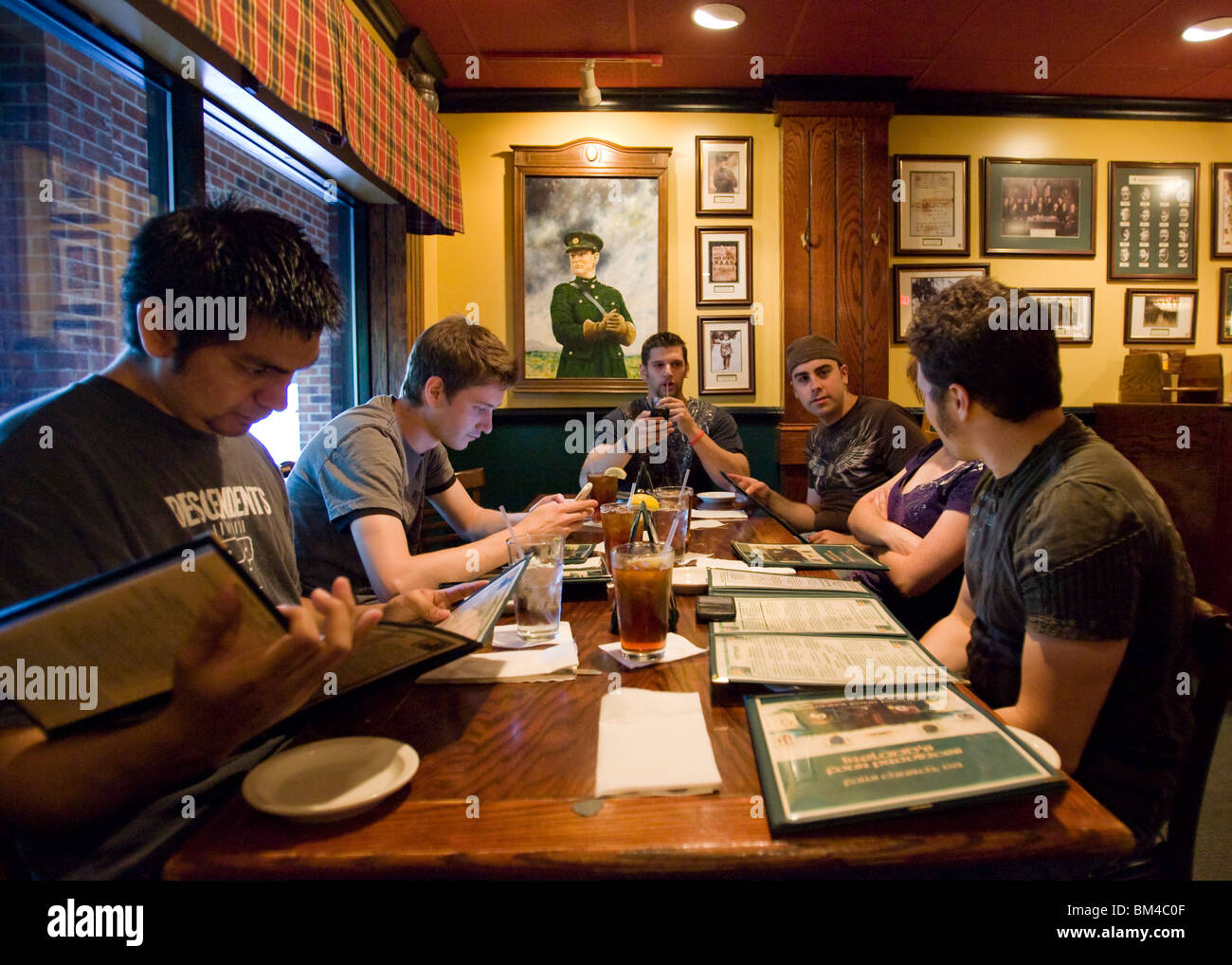 Young people reading restaurant menu Stock Photo - Alamy