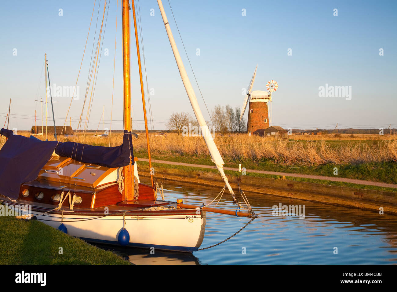 Horsey wind pump seen past a traditional wood built yacht Stock Photo ...