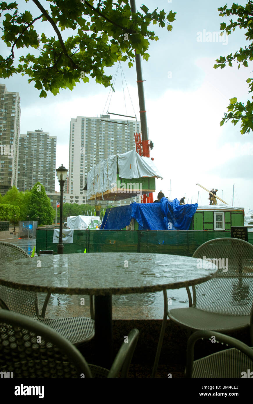 Workers construct a temporary prefabricated cottage home at the World ...
