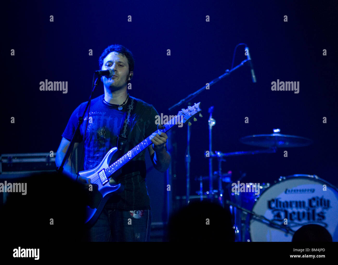 Rock band guitarist singing back vocals on stage Stock Photo - Alamy
