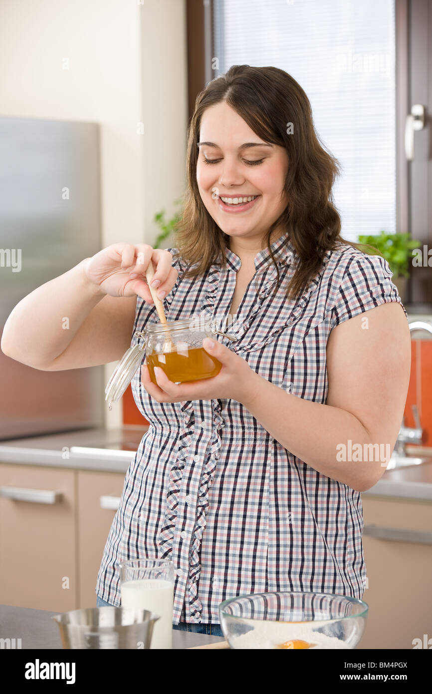 Bake - happy woman with ingredients in kitchen prepare cake holding ...