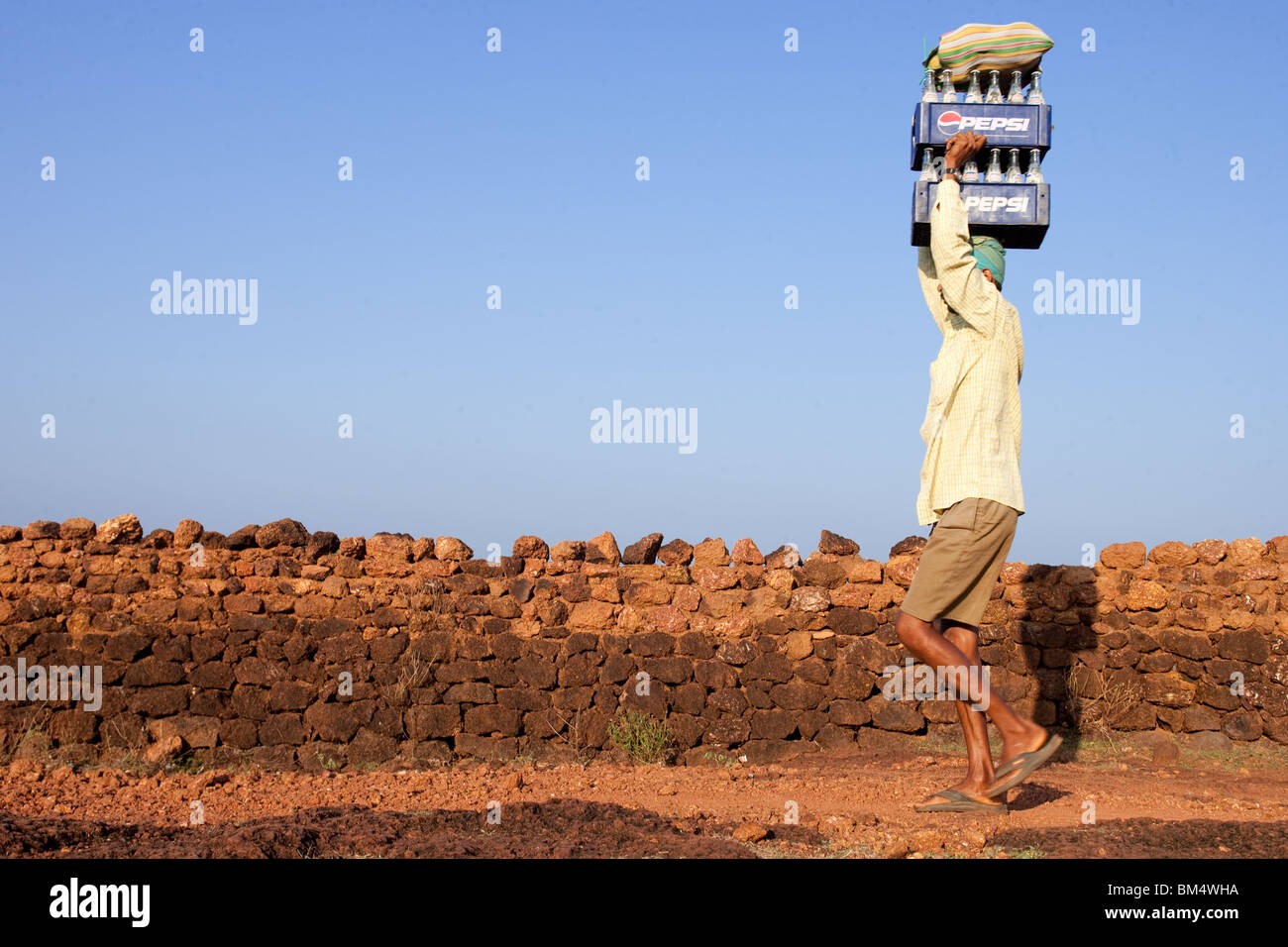 Man carrying a heavy load on his head in South India Stock Photo - Alamy