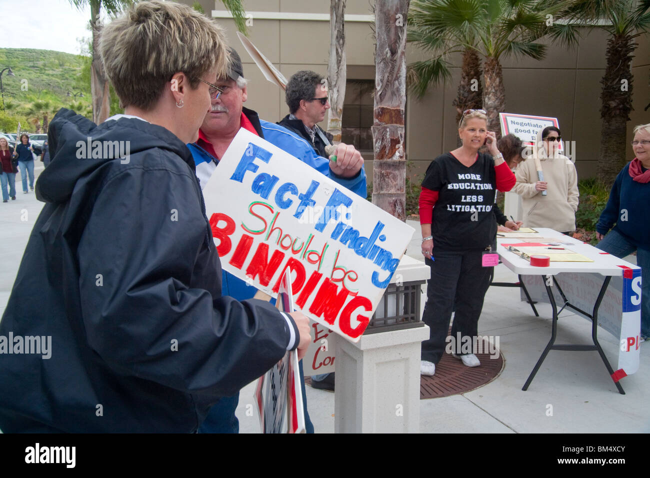 Carrying signs, protesting school teachers rally over proposed pay cuts ...