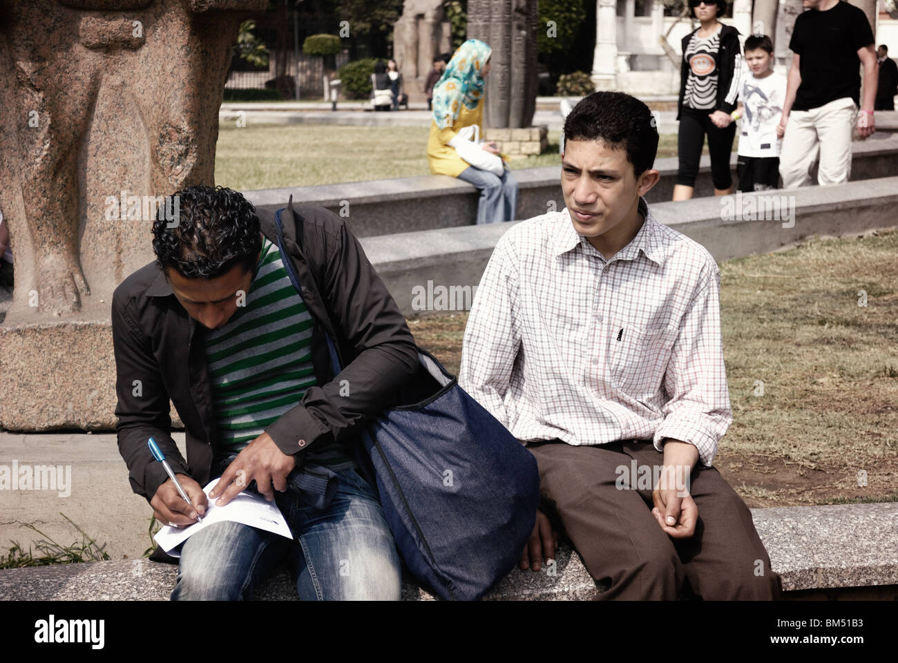 Two young Egyptian men sitting in courtyard of the Egyptian Museum ...