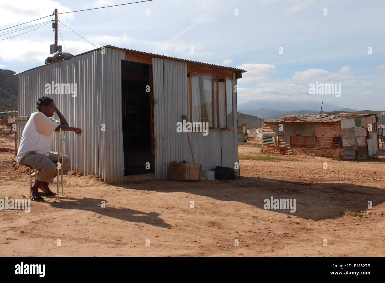 woman, sitting in front of het shack Stock Photo - Alamy