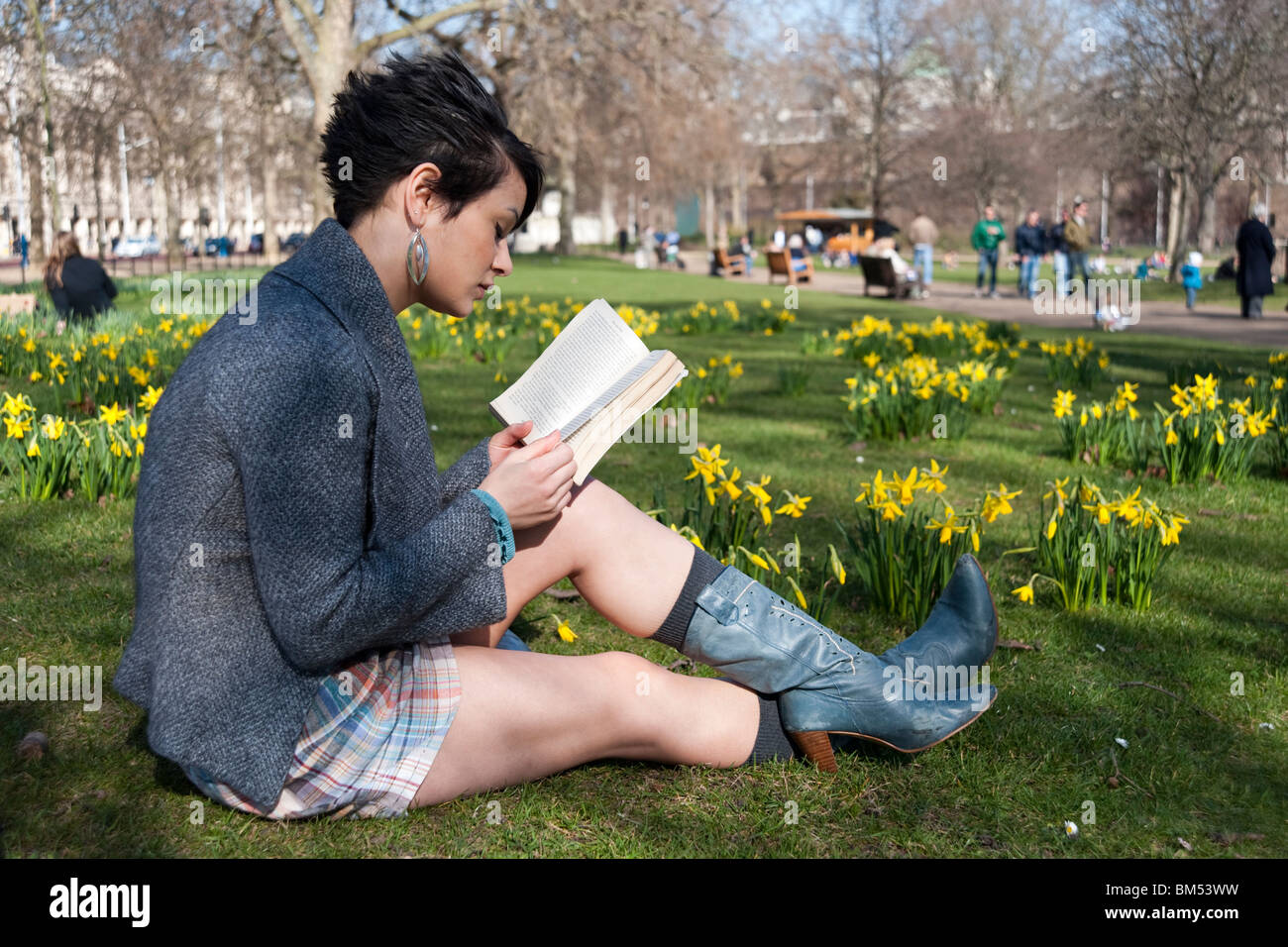 Young woman reading a book in St James's Park, London, England, UK ...