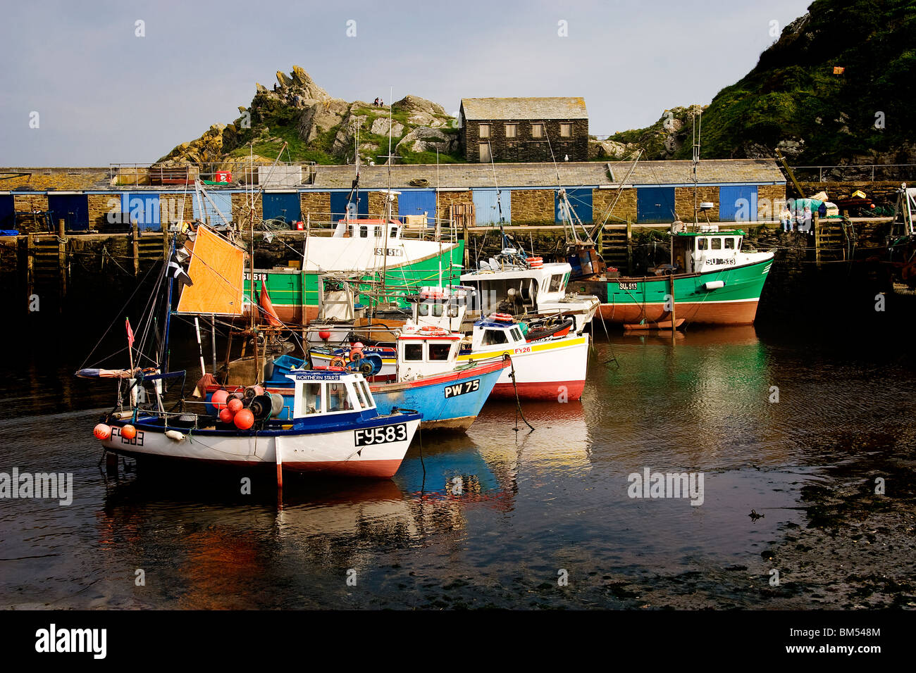 A row of fishing boats rest inside Polperro harbour Stock Photo - Alamy