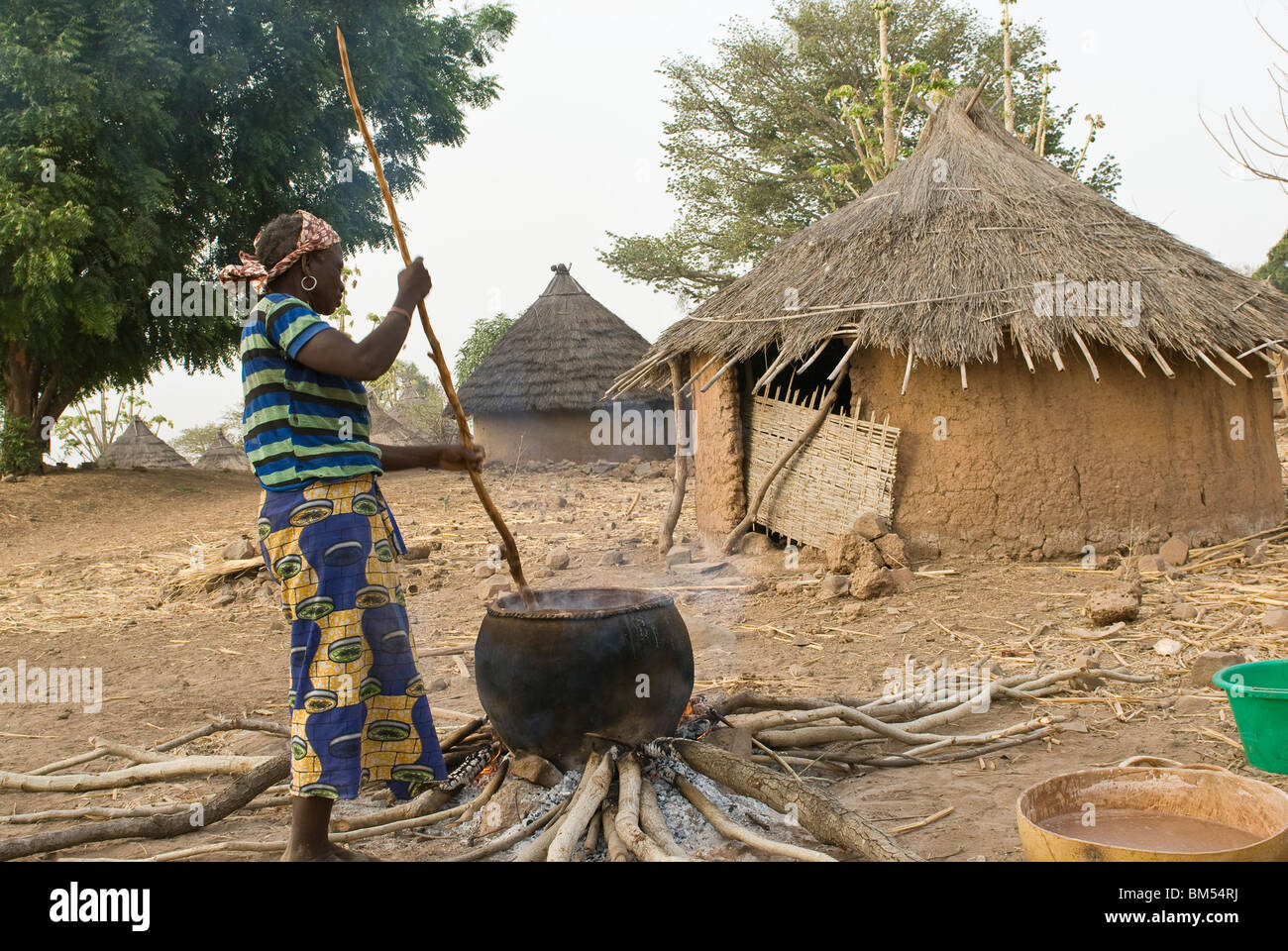 African bedik women cooking crushed peanuts on the fire, Iwol village ...
