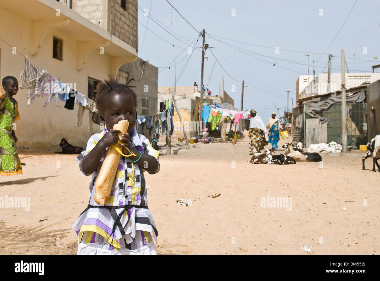 Young girl with a loaf of bread in the streets of Sant Louis, Senegal ...