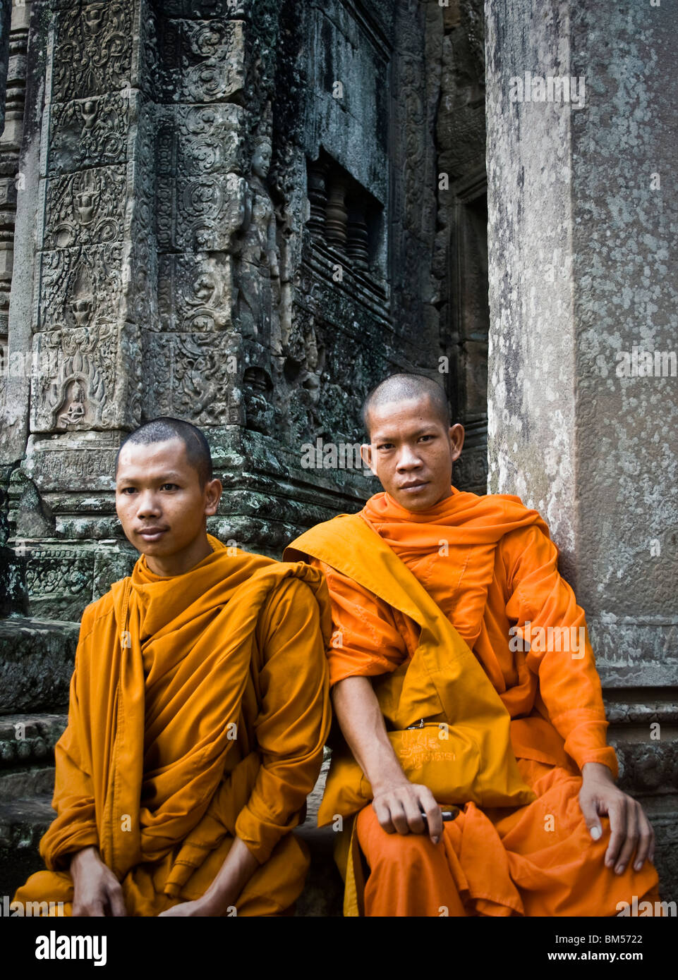 Two monks sit down at Bayon, Angkor Thom, one of the temples of Angkor ...