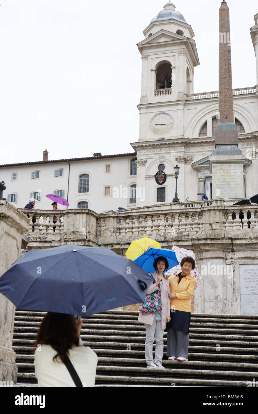 Asian tourists take a photo in Trinità de Monti steps in winter rainy ...