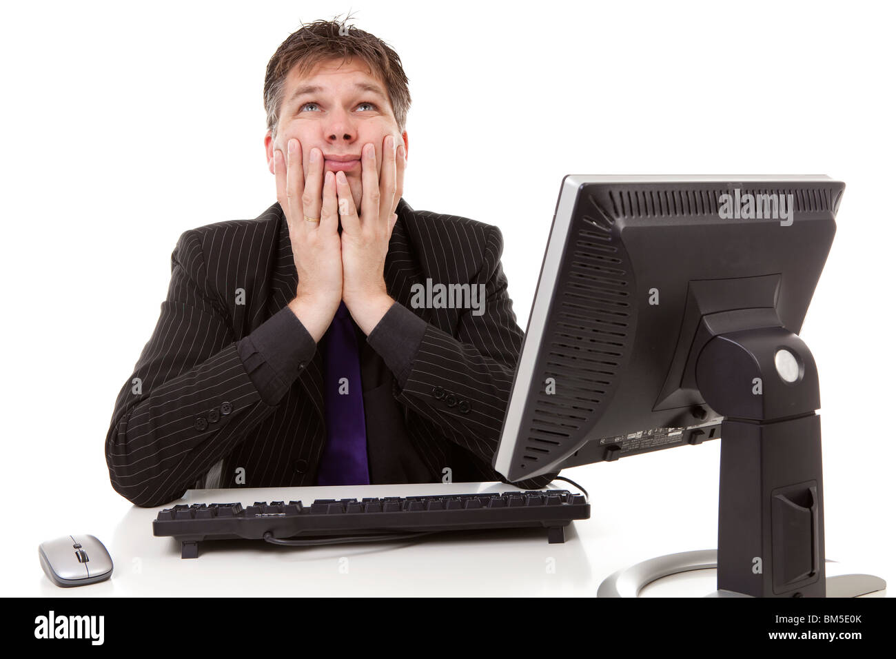 Businessman sitting behind desk is in despair, looking in the sky, over ...