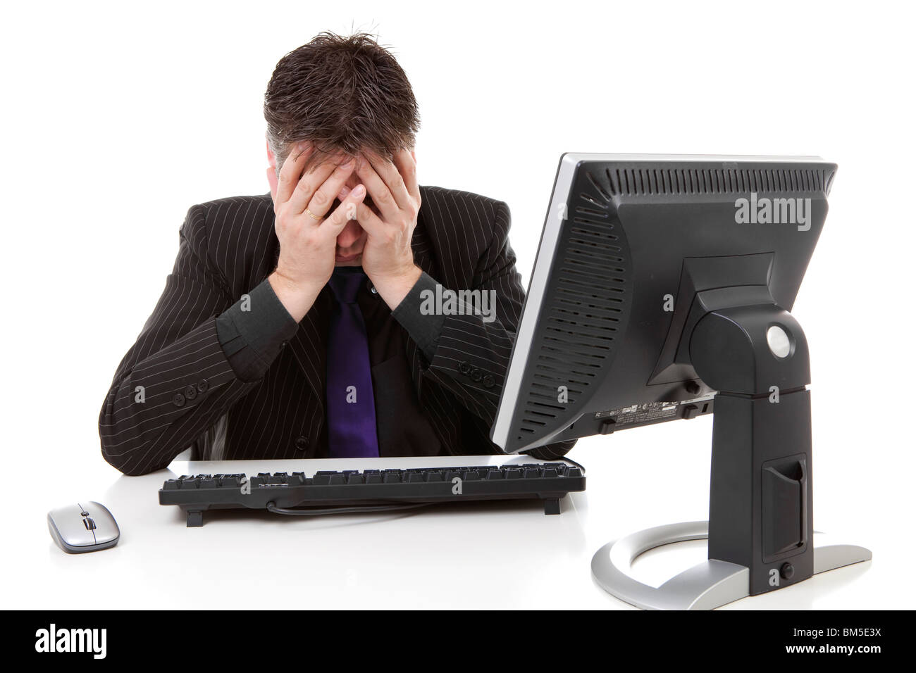 Businessman sitting behind desk is in despair, covering his eyes, over ...