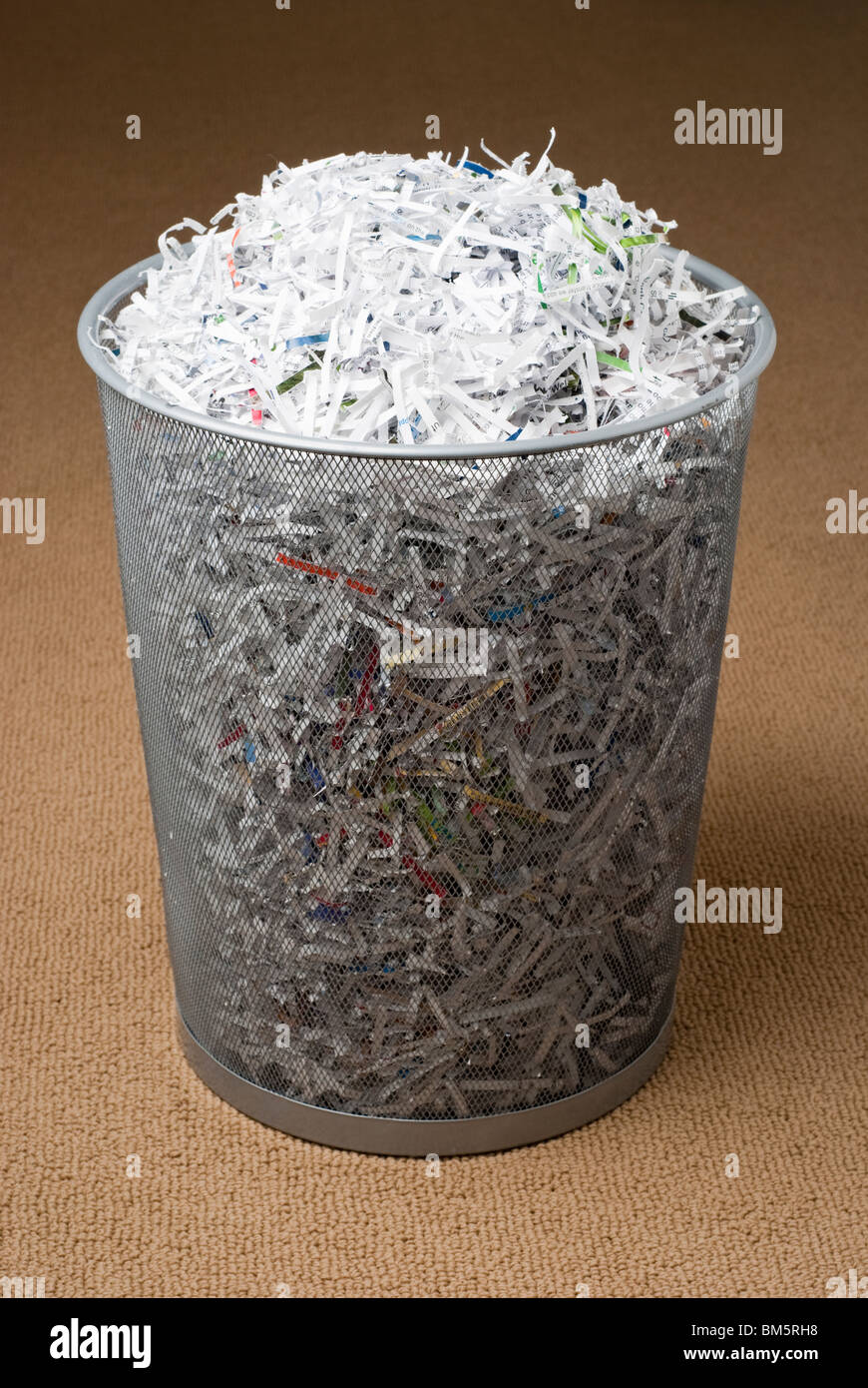 wastepaper basket filled with shredded paper on a carpet Stock Photo ...