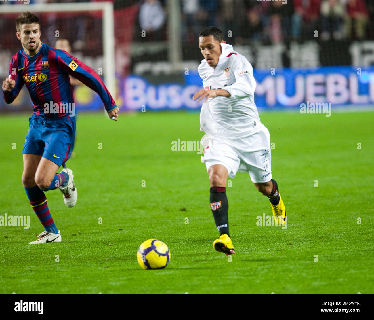Adriano with the ball pursued by Pique Stock Photo - Alamy