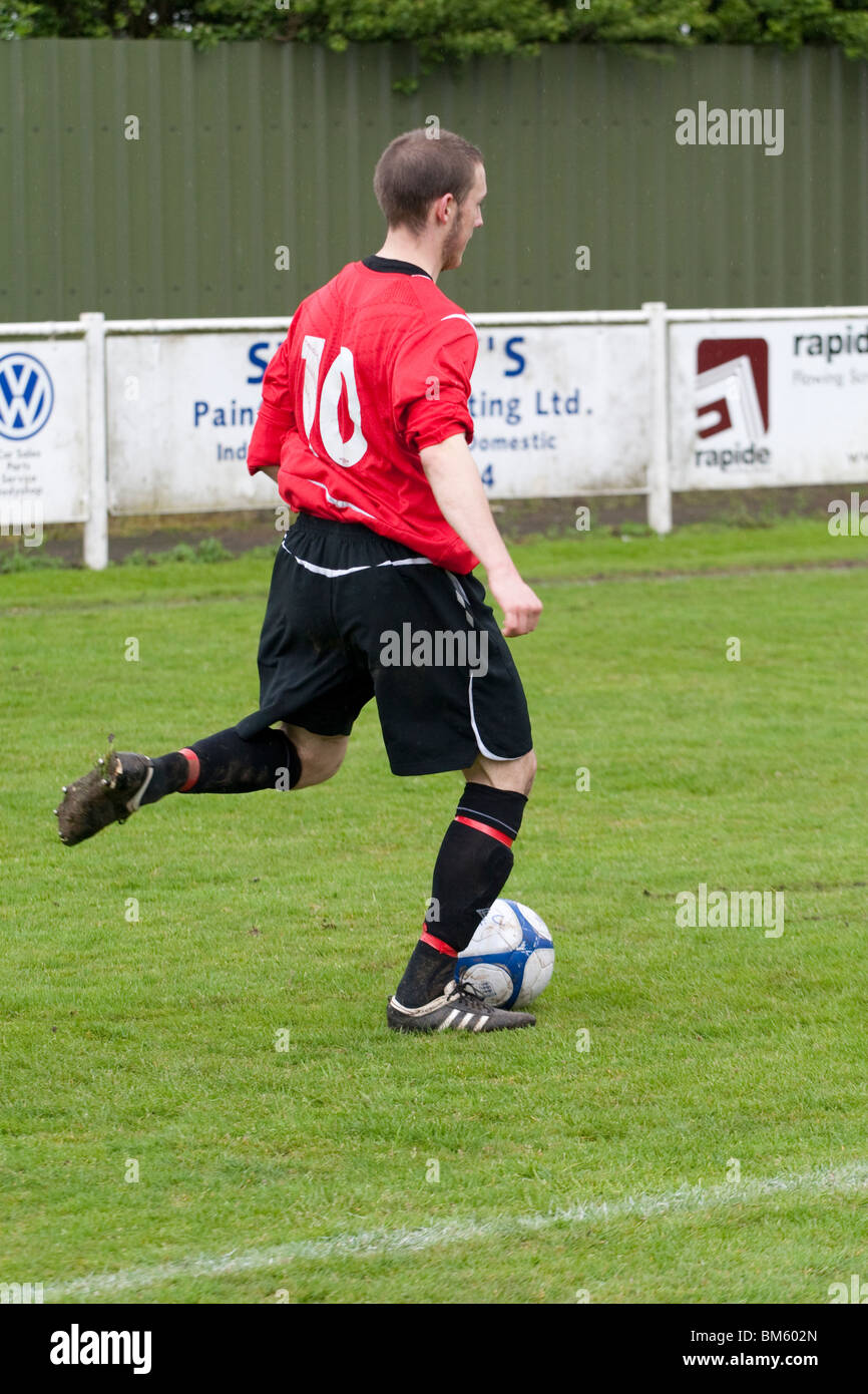 A local footballer making a pass Stock Photo - Alamy