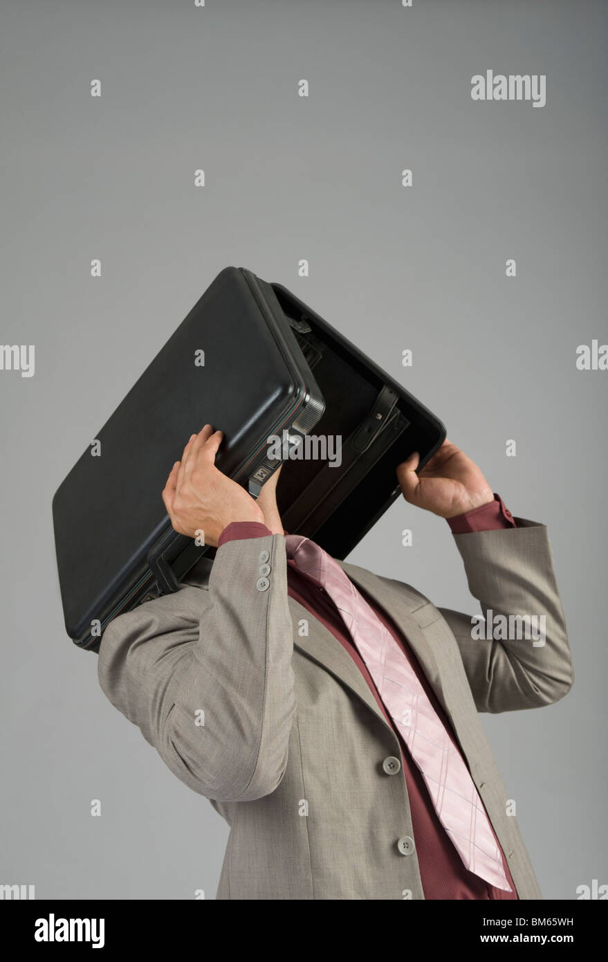Businessman holding a briefcase over his head Stock Photo - Alamy