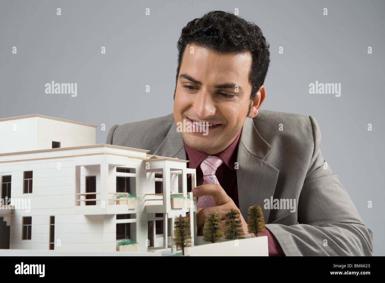 Businessman looking at a model home in an office Stock Photo - Alamy