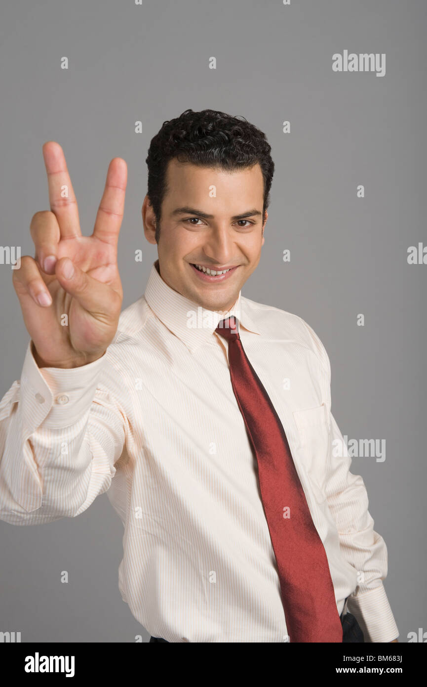 Portrait of a businessman showing victory sign Stock Photo - Alamy Portrait of a businessman showing victory sign Stock Photo - Alamy