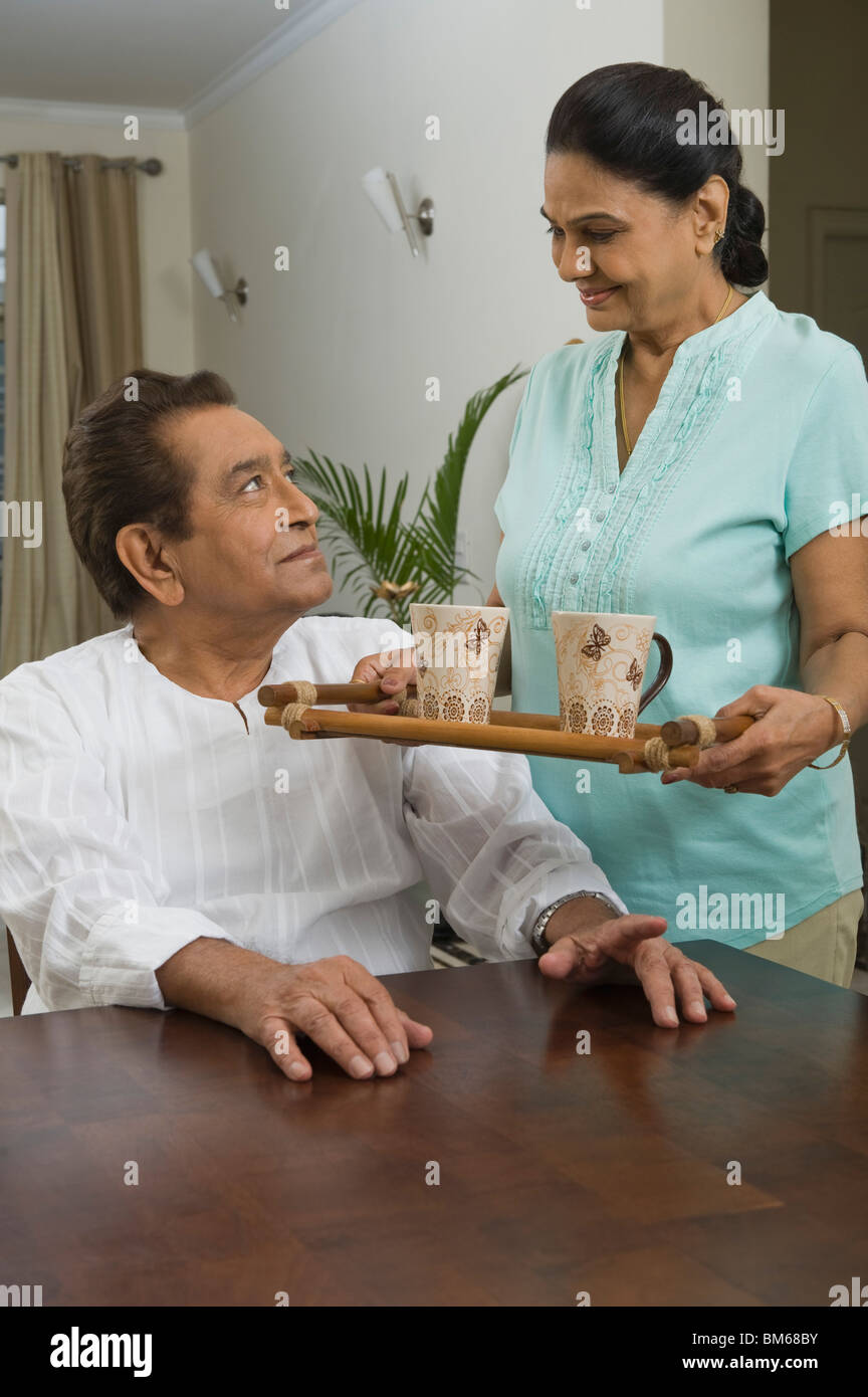 Woman bringing tea for a man Stock Photo - Alamy